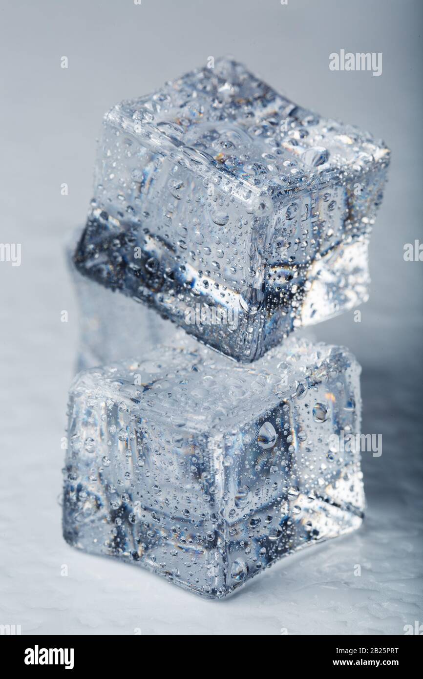 Ice cubes in the form of a pyramid with water drops close - up in macro ...