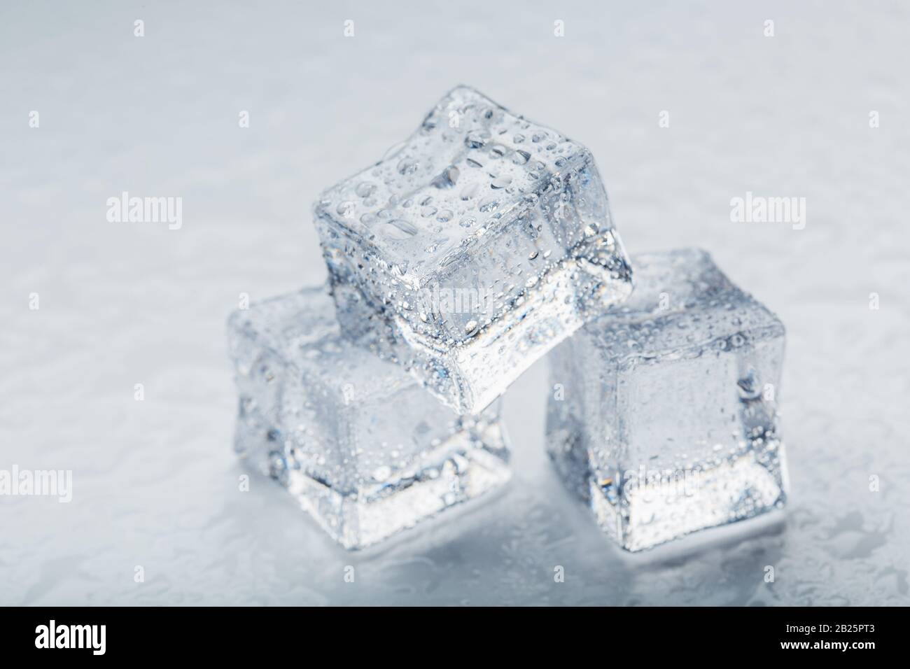 Ice cubes in the form of a pyramid with water drops close - up in macro ...