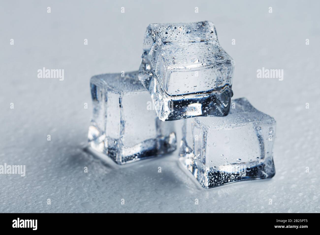 Ice cubes in the form of a pyramid with water drops close - up in macro ...