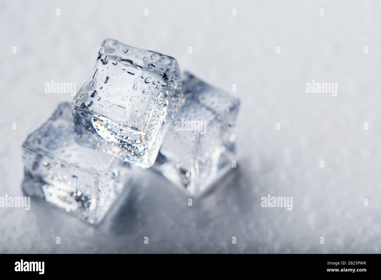 Ice cubes in the form of a pyramid with water drops close - up in macro ...