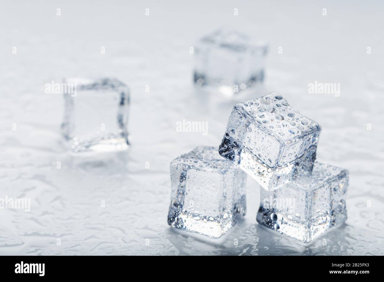 Ice cubes in the form of a pyramid with water drops close - up in macro ...
