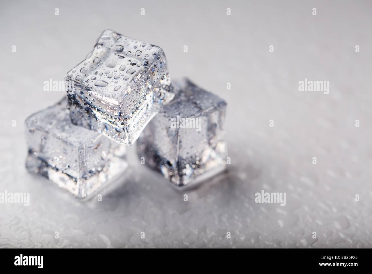 Ice cubes in the form of a pyramid with water drops close - up in macro ...
