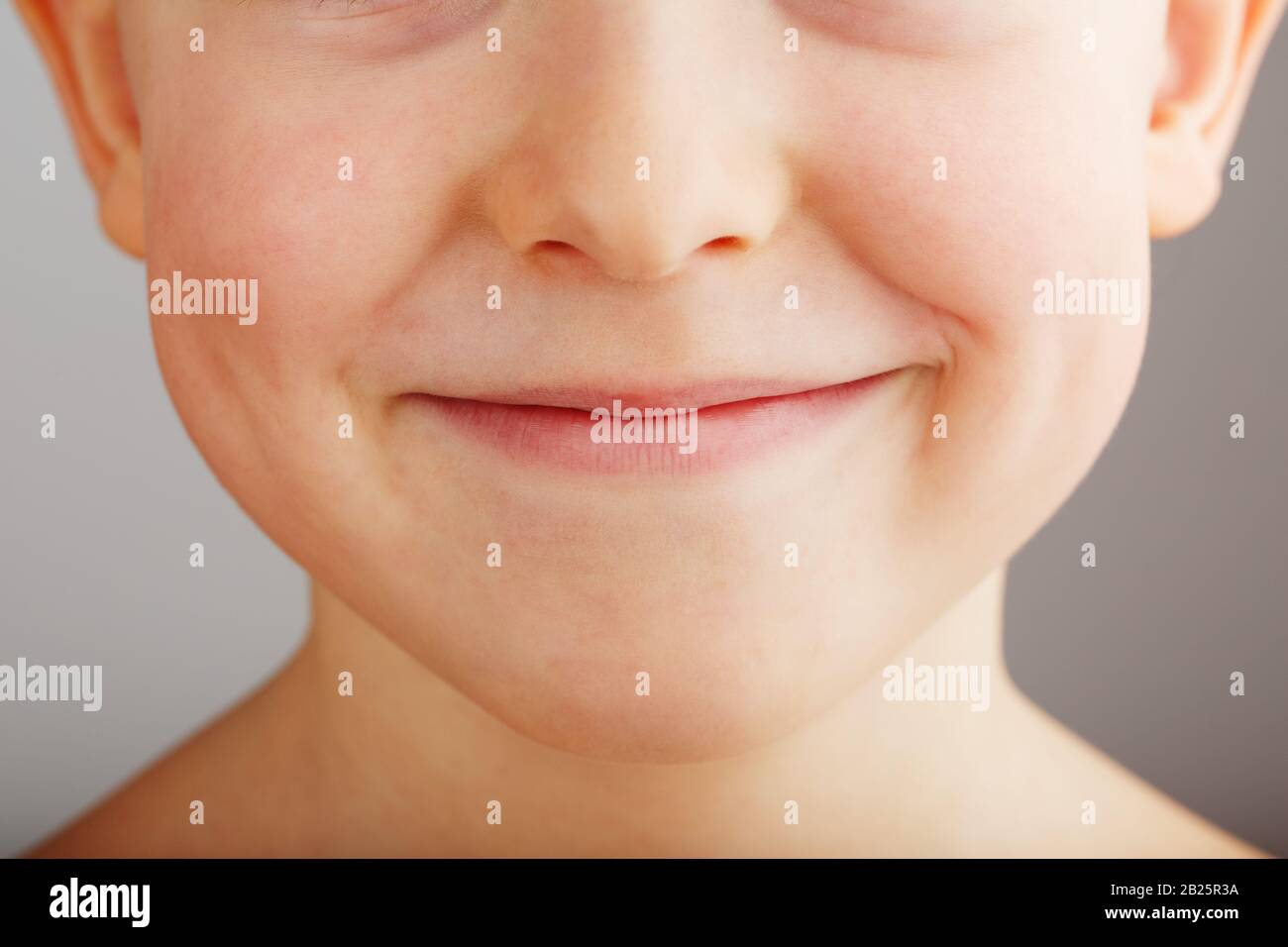 A child's smile in a frame, lips part of the face. Portrait of a ...