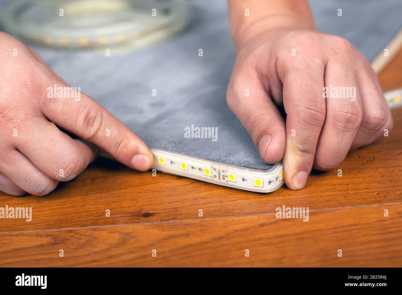 worker installs strip LED lighting. installation of decorative diode ...