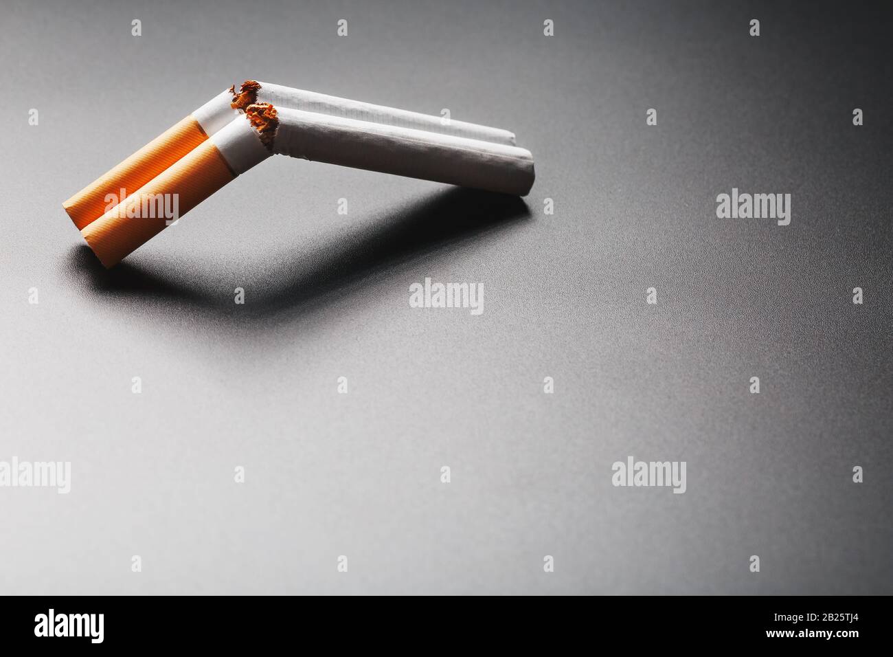 Two cigarettes in the form of a double-barreled shotgun on a black ...