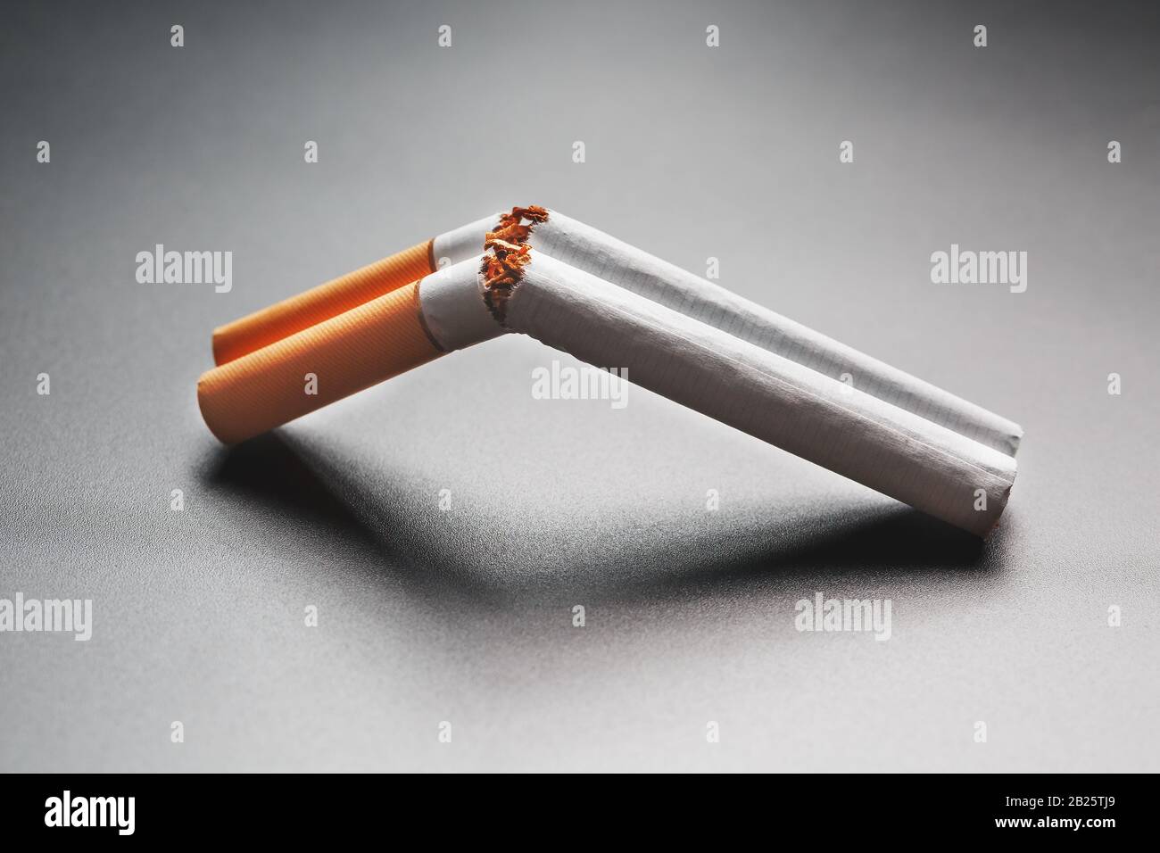 Two cigarettes in the form of a double-barreled shotgun on a black ...