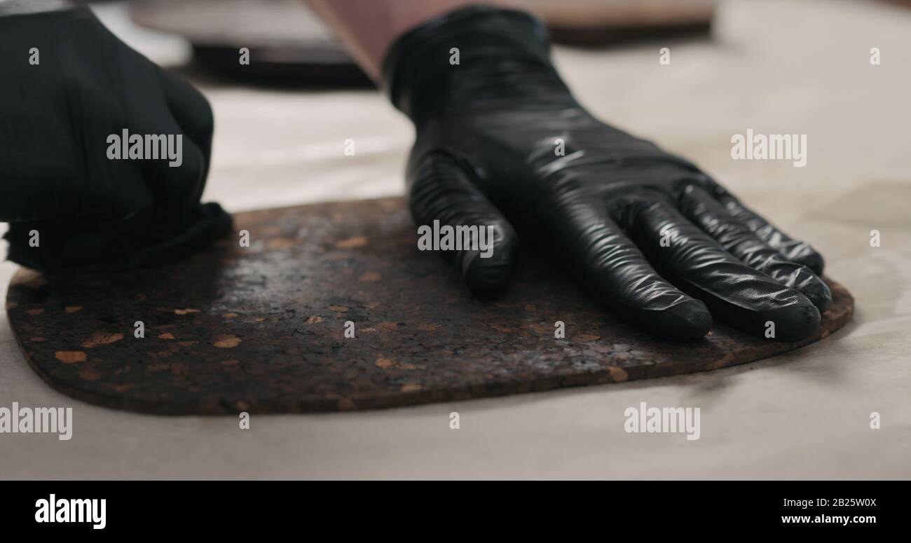 man hands applying oil finish on dark cork mat , wide photo Stock Photo ...