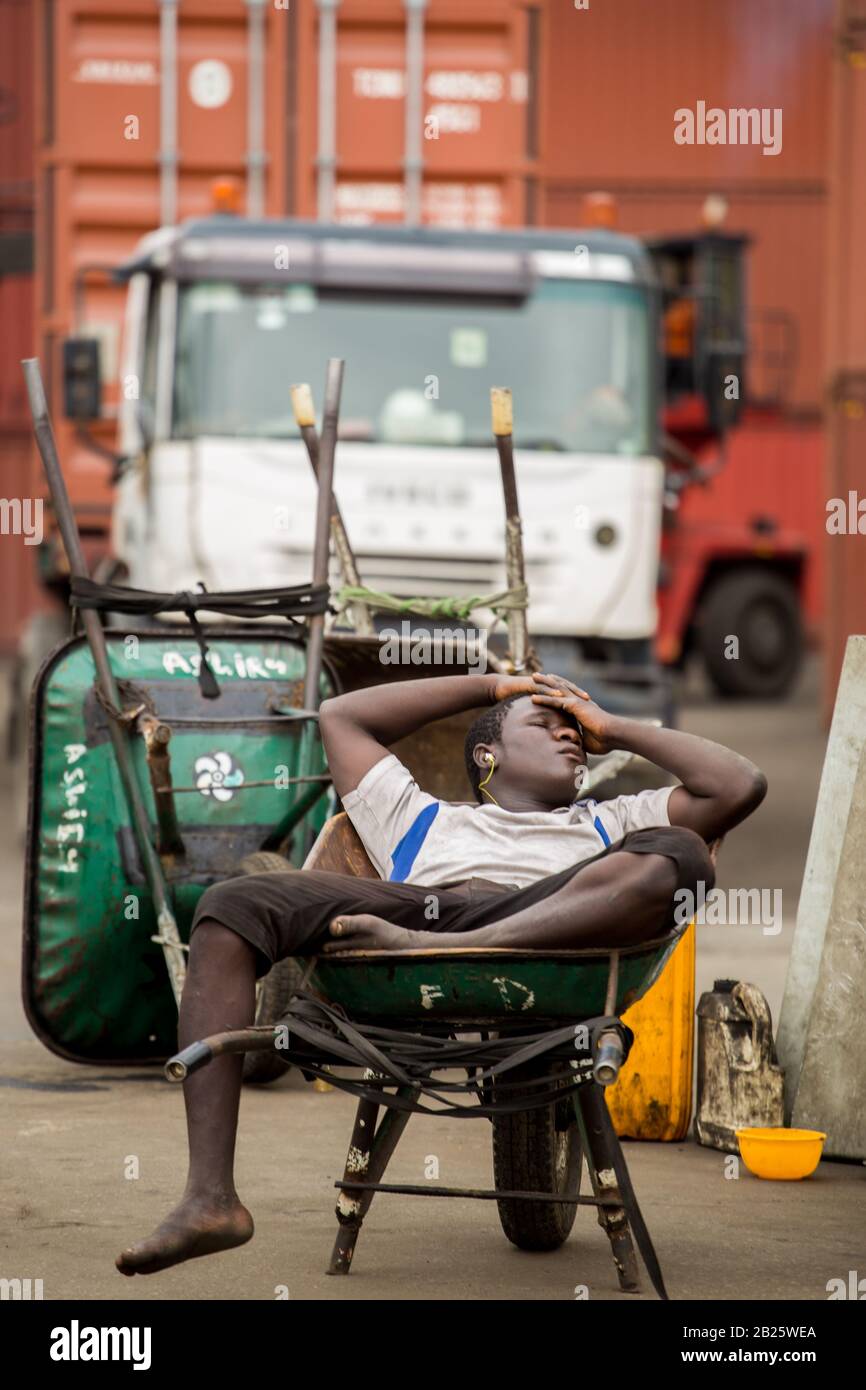 A man sleeping inside a wheel-barrow on a street in Nigeria Stock Photo ...