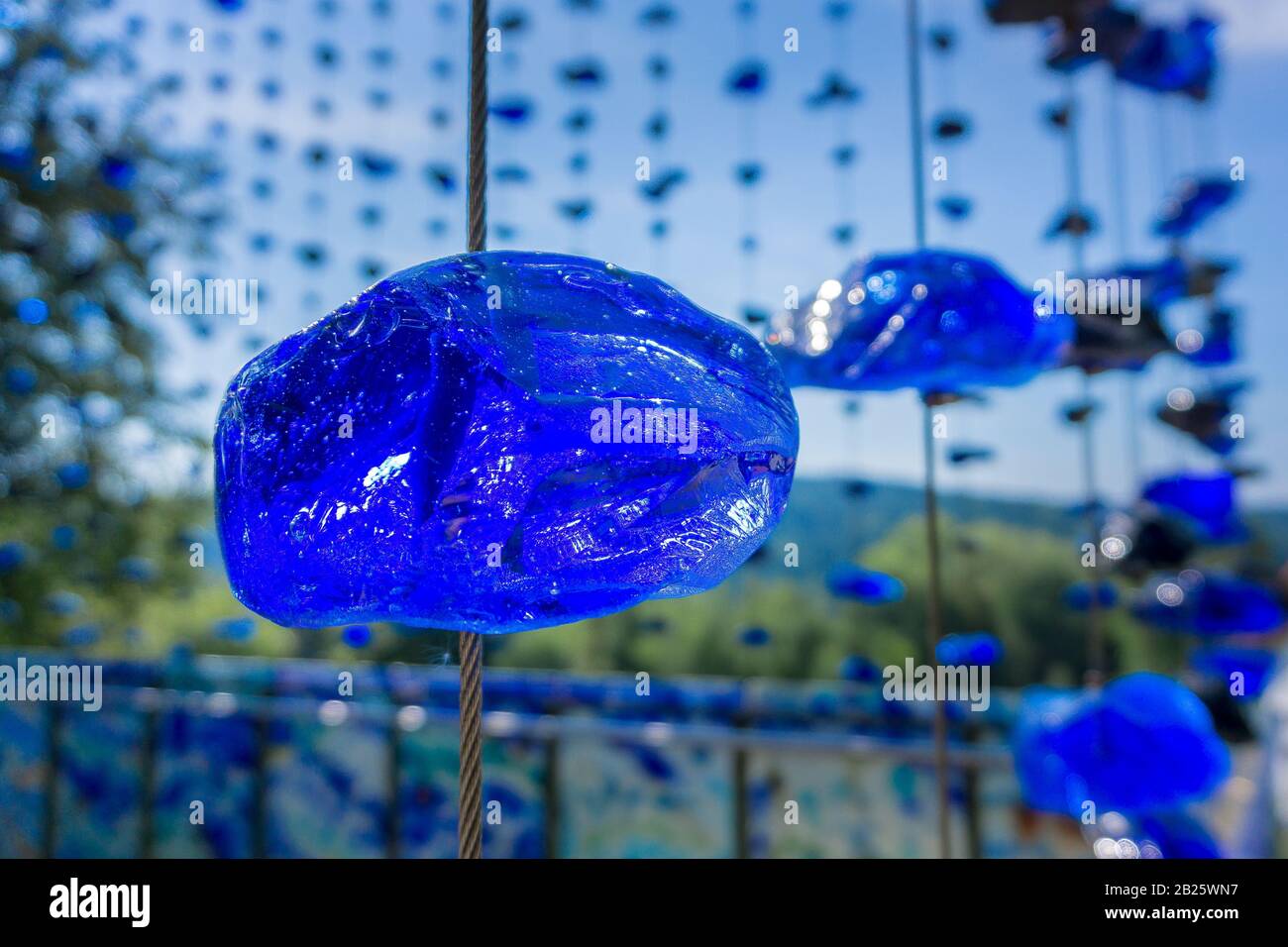 a broken glass stone suspended from a steel cable Stock Photo - Alamy