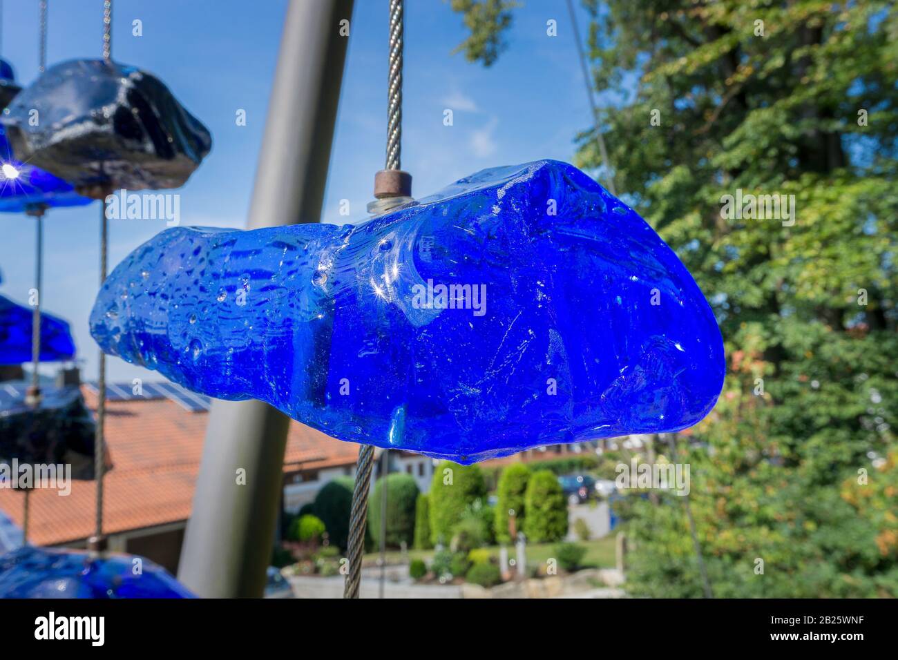 a broken glass stone suspended from a steel cable Stock Photo - Alamy