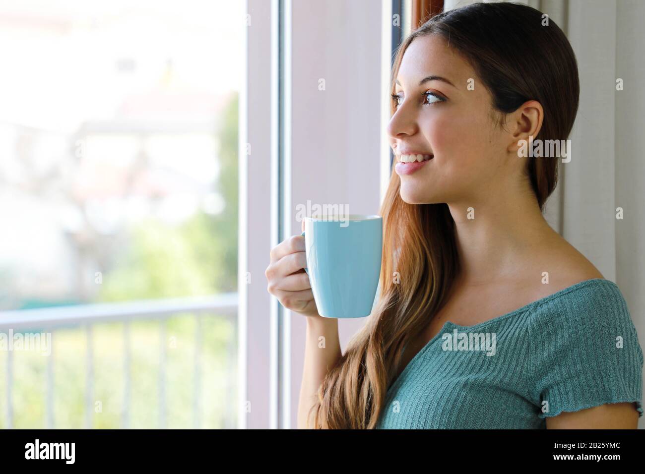 Woman at window with cup hi-res stock photography and images - Alamy