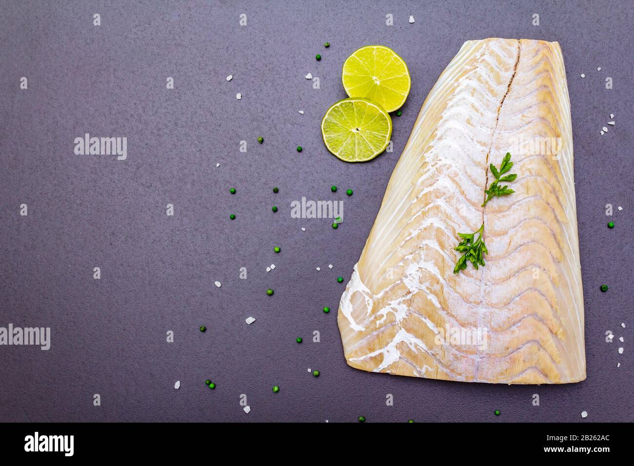 Fresh pollock fillet with lime, green pepper, salt and parsley. Concept ...