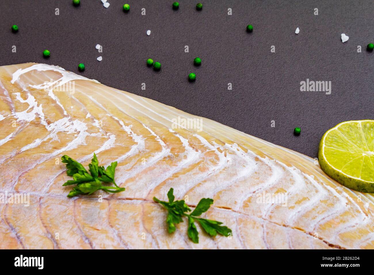 Fresh pollock fillet with lime, green pepper, salt and parsley. Concept ...
