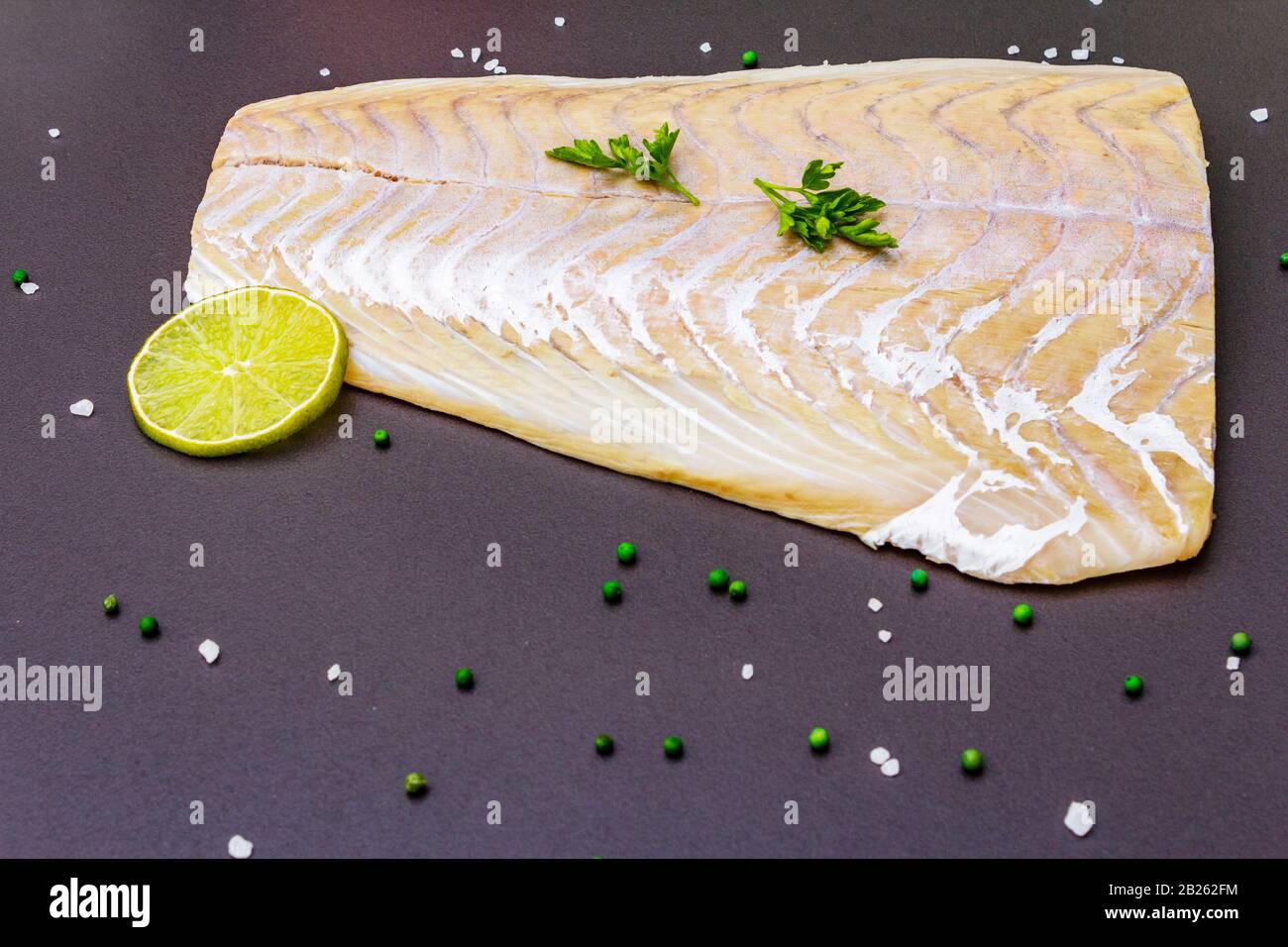 Fresh pollock fillet with lime, green pepper, salt and parsley. Concept ...