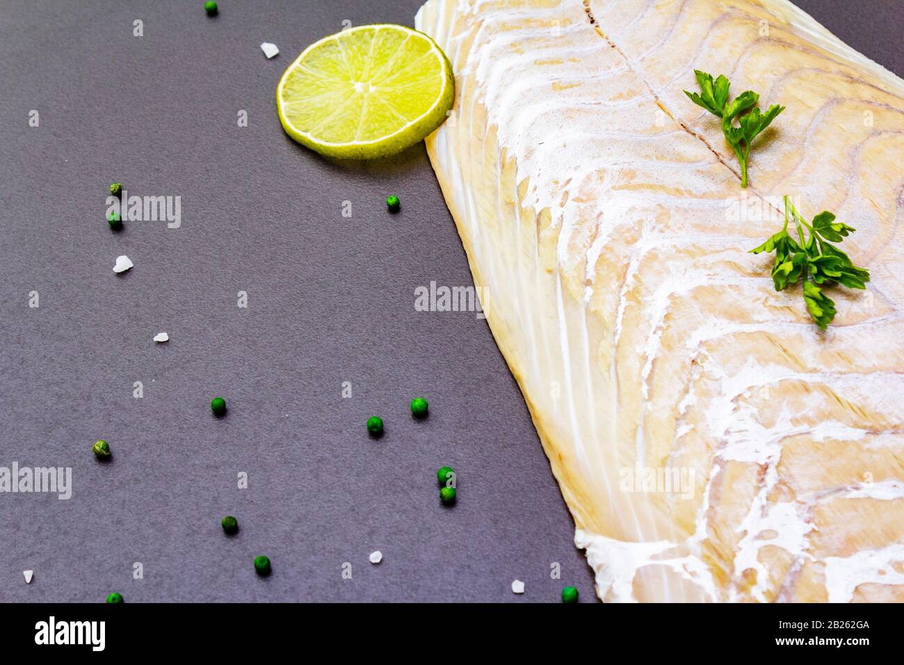 Fresh pollock fillet with lime, green pepper, salt and parsley. Concept ...