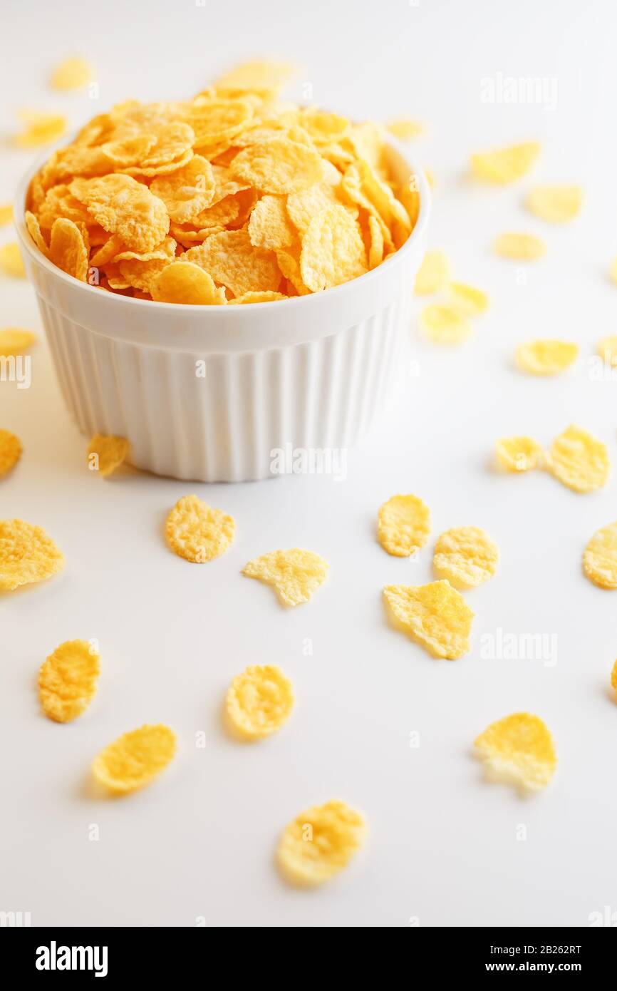 White cup with golden corn flakes, isolated on white background. Hopya ...