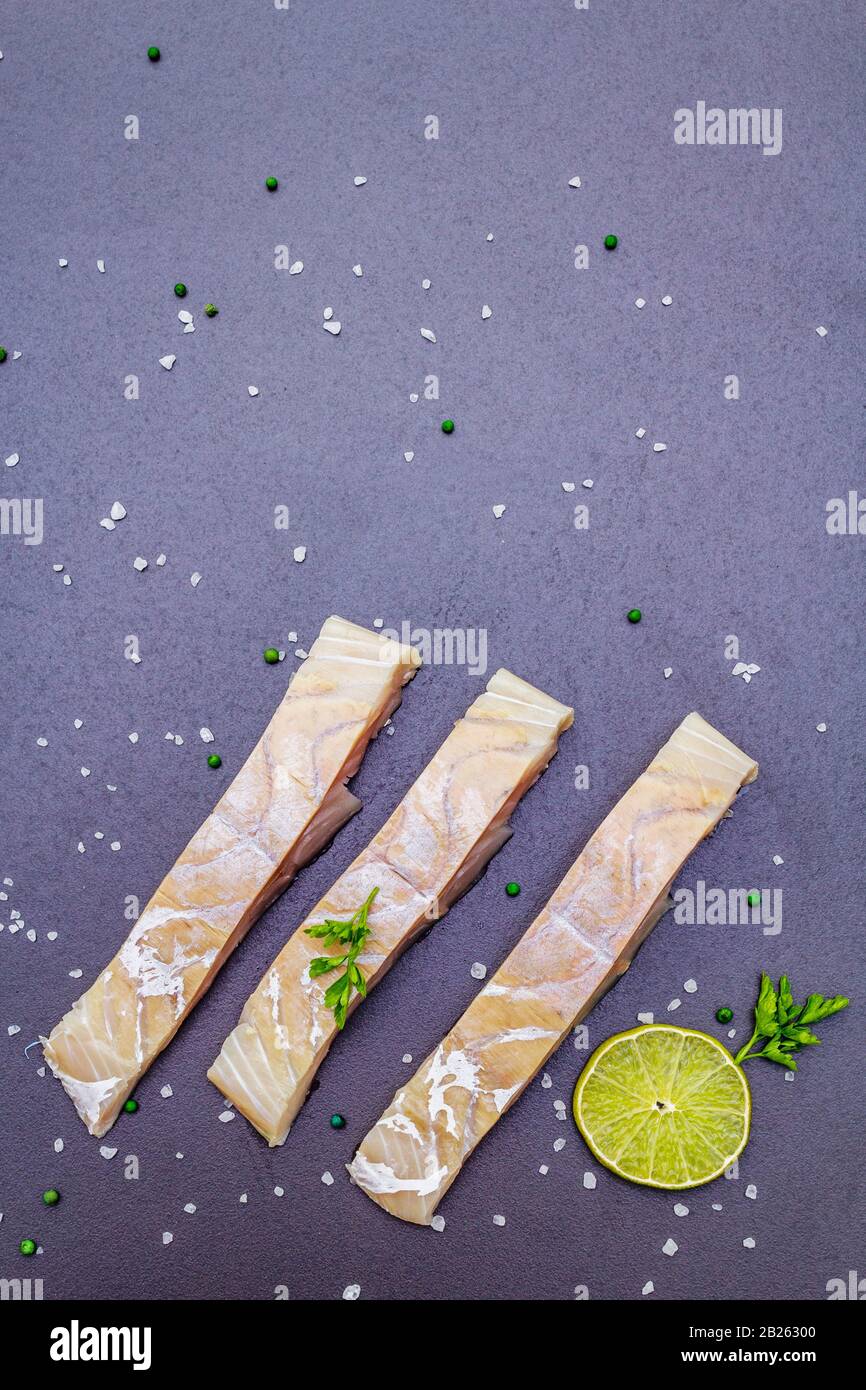 Fresh pollock pieces with lime, green pepper, salt and parsley. Concept ...