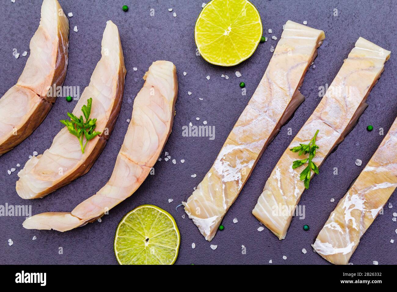 Fresh pollock pieces with lime, green pepper, salt and parsley. Concept ...