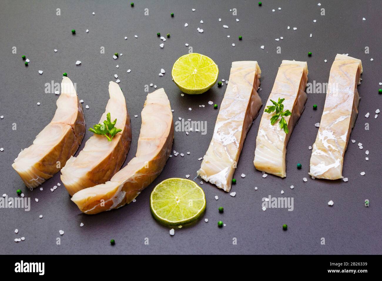 Fresh pollock pieces with lime, green pepper, salt and parsley. Concept ...