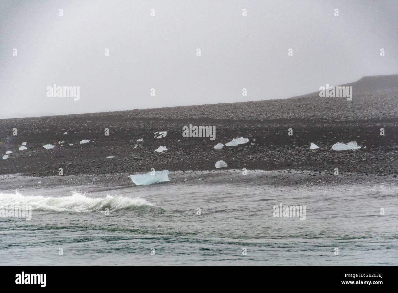 Diamond beach black sand crystal clear piece of ice washed up on ...