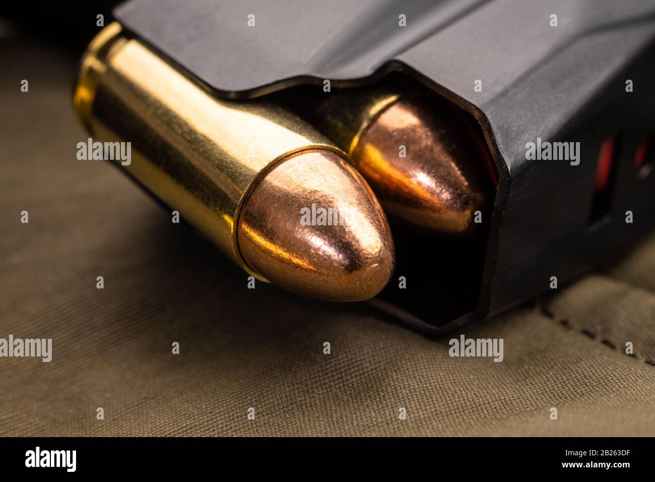 Closeup of 9mm cartridge in pistol grip. Cartridge background. Closeup ...