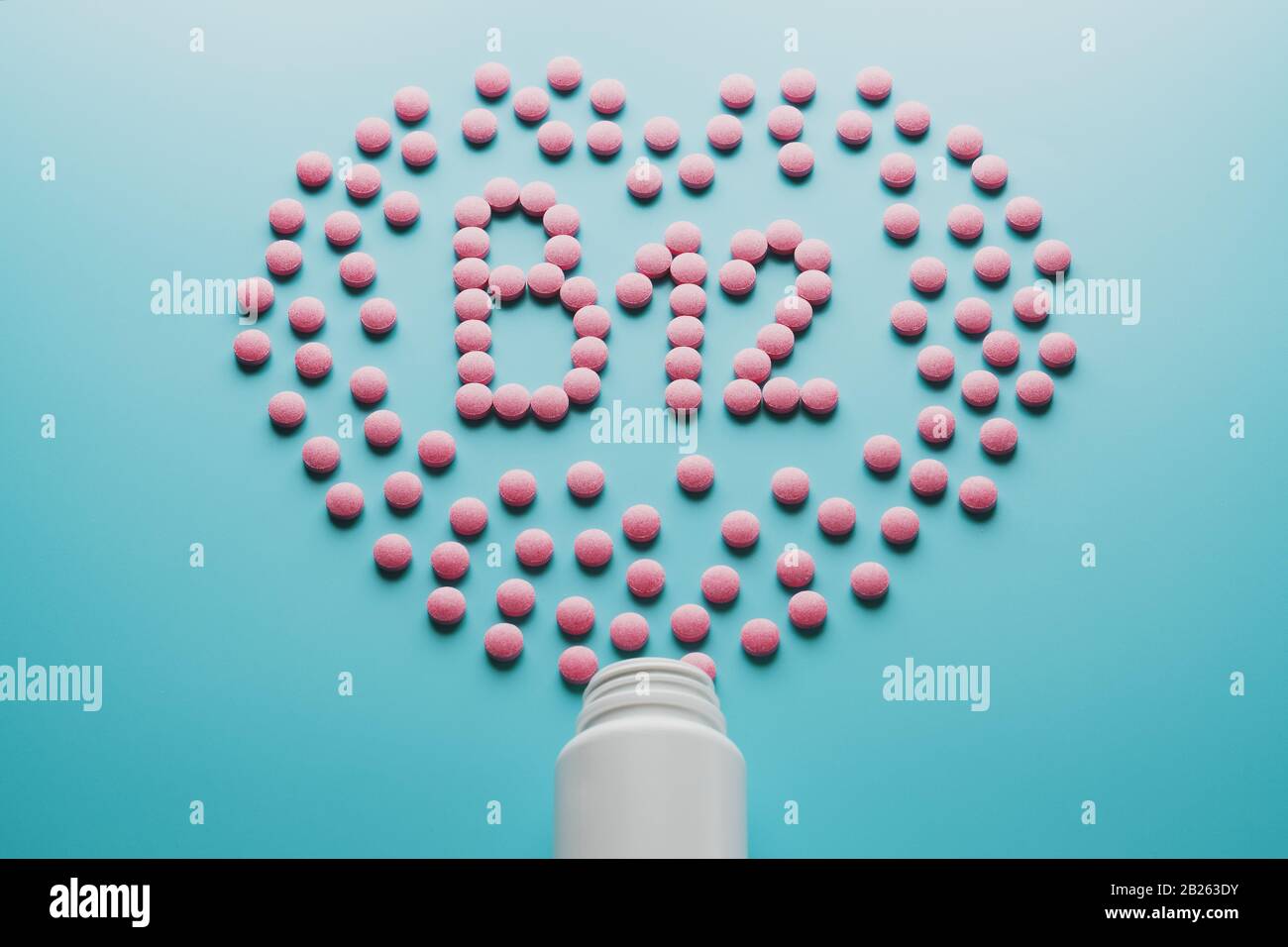 Pink tablets in the form of B12 in the heart on a blue background ...