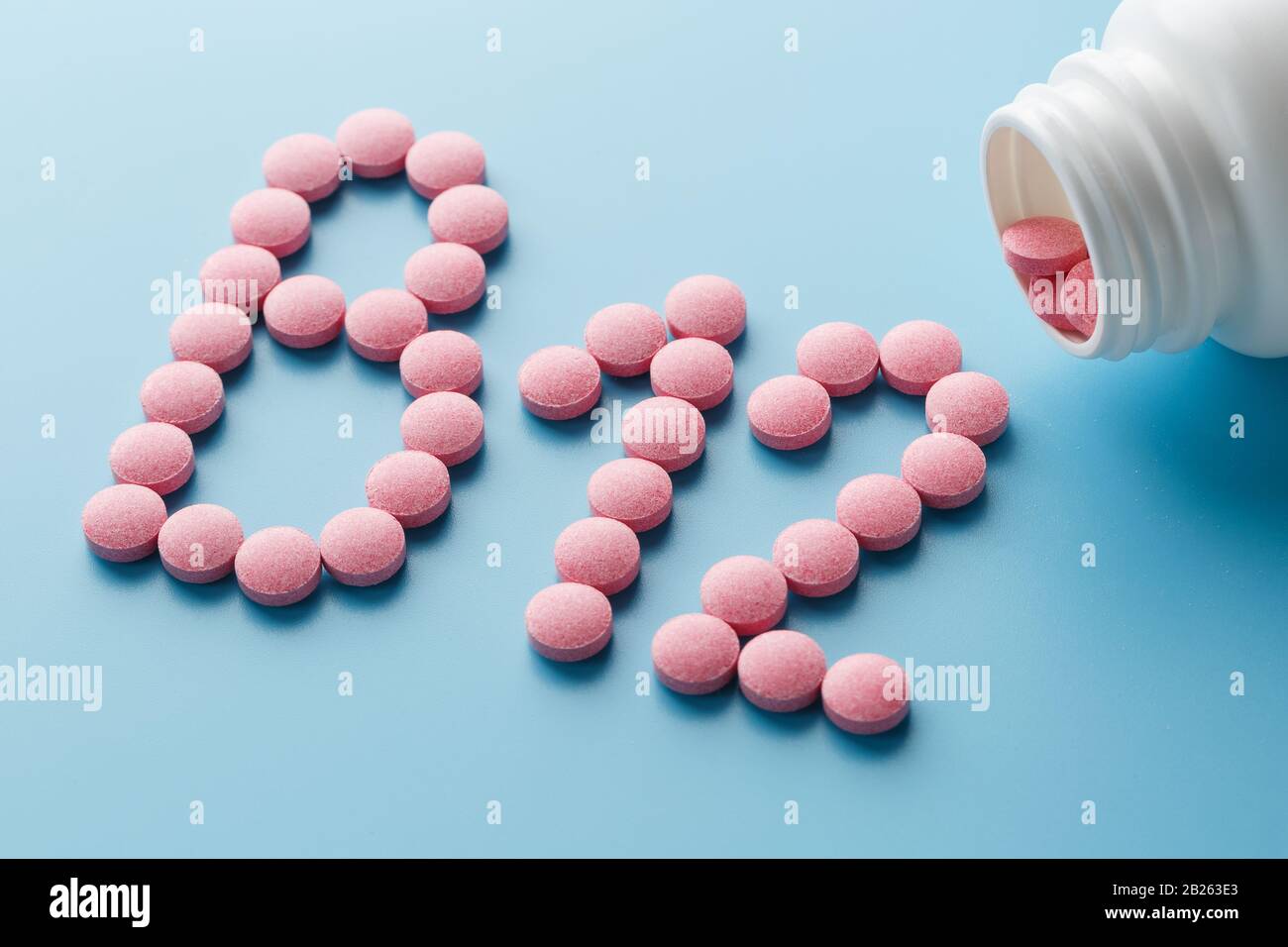 Pink Vitamins in the shape of the letter B 12 on a blue background ...