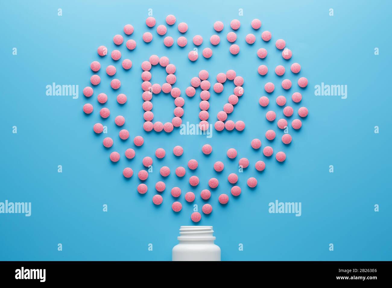 Pink tablets in the form of B12 in the heart on a blue background ...