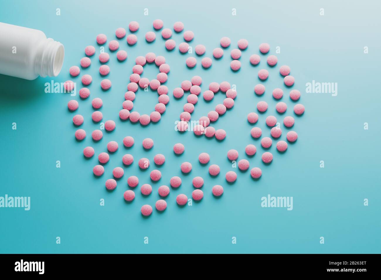 Pink tablets in the form of B12 in the heart on a blue background ...