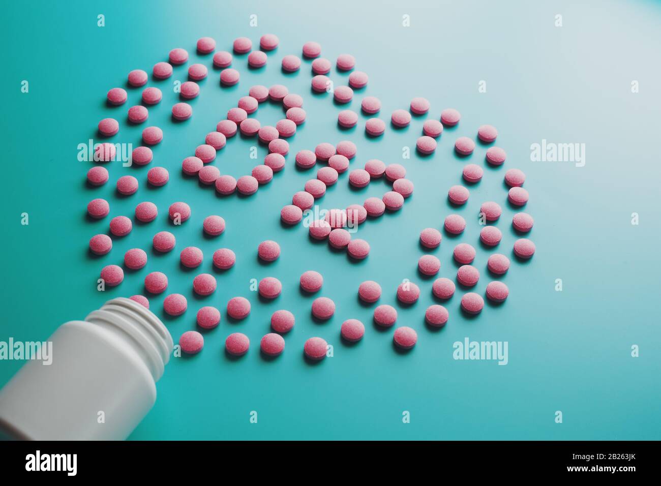 Pink tablets in the form of B12 in the heart on a blue background ...