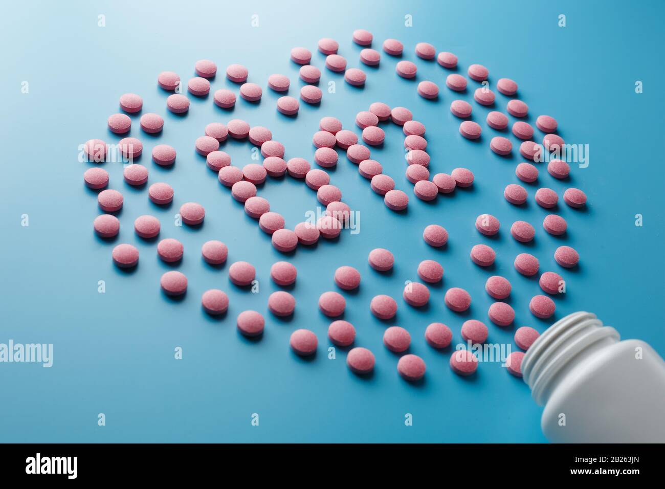 Pink tablets in the form of B12 in the heart on a blue background ...