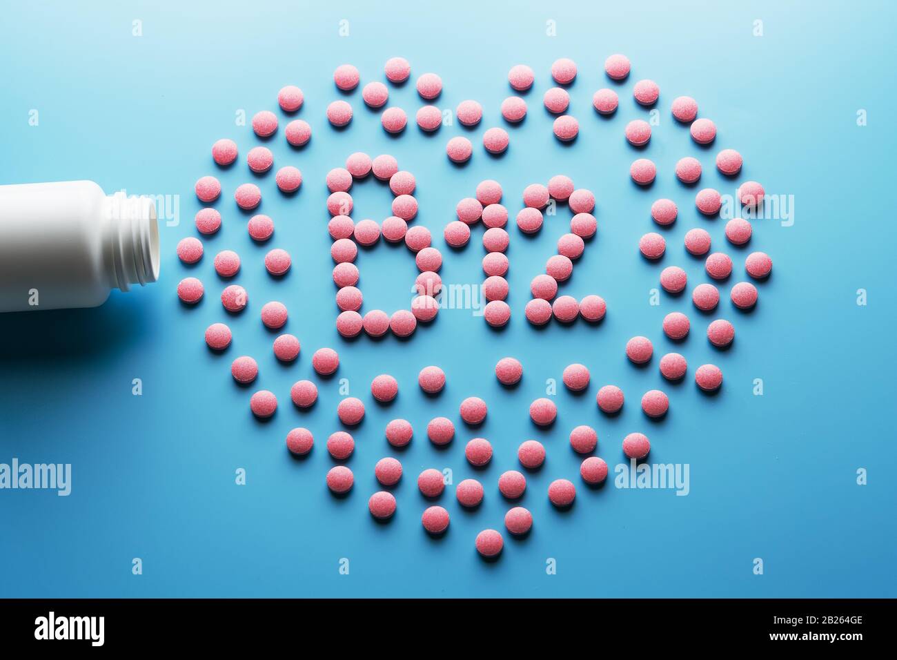 Pink tablets in the form of B12 in the heart on a blue background ...