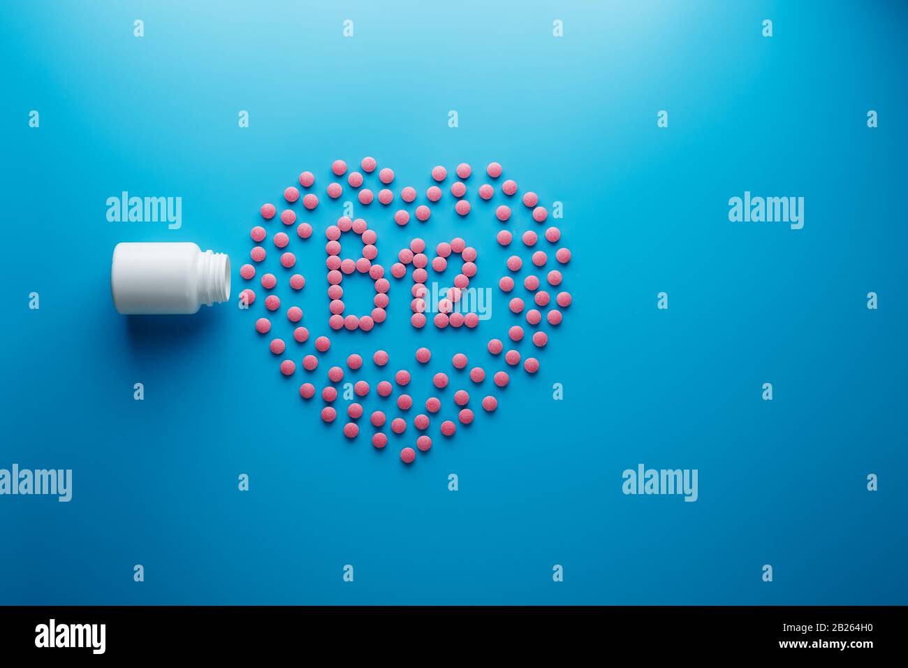 Pink tablets in the form of B12 in the heart on a blue background ...