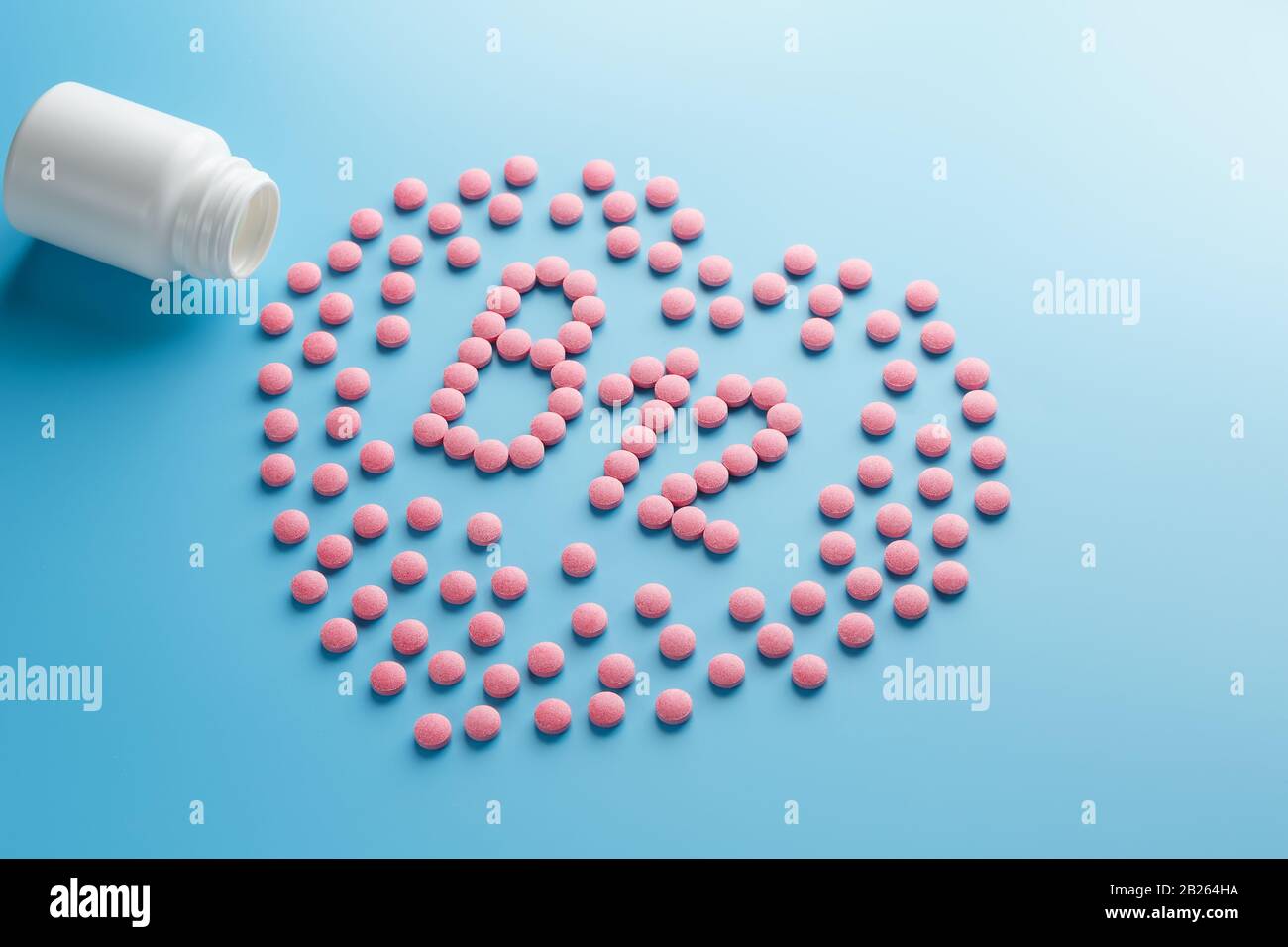 Pink tablets in the form of B12 in the heart on a blue background ...