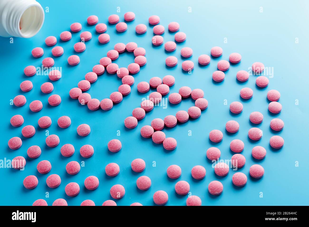Pink tablets in the form of B12 in the heart on a blue background ...