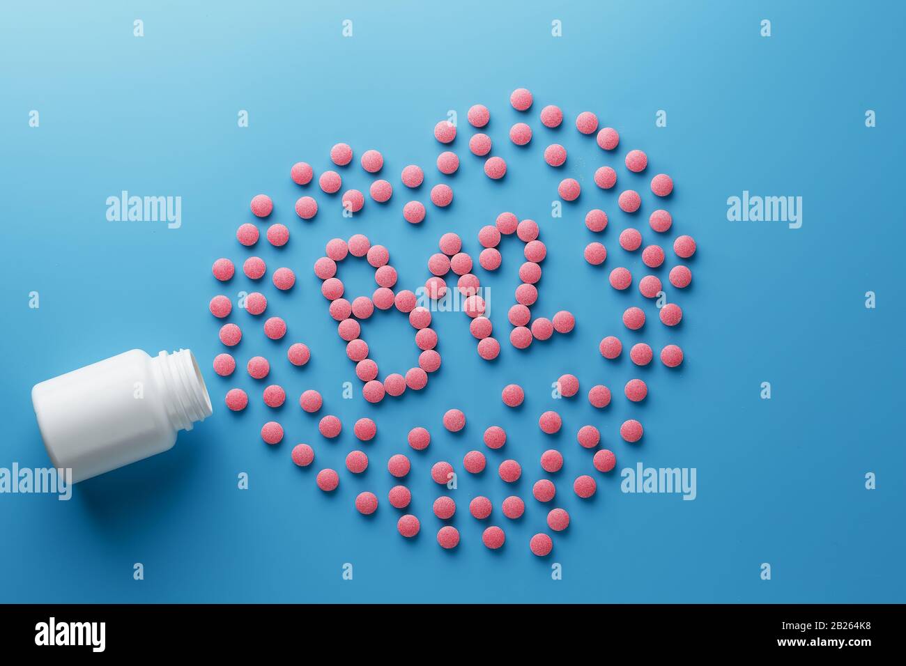 Pink tablets in the form of B12 in the heart on a blue background ...