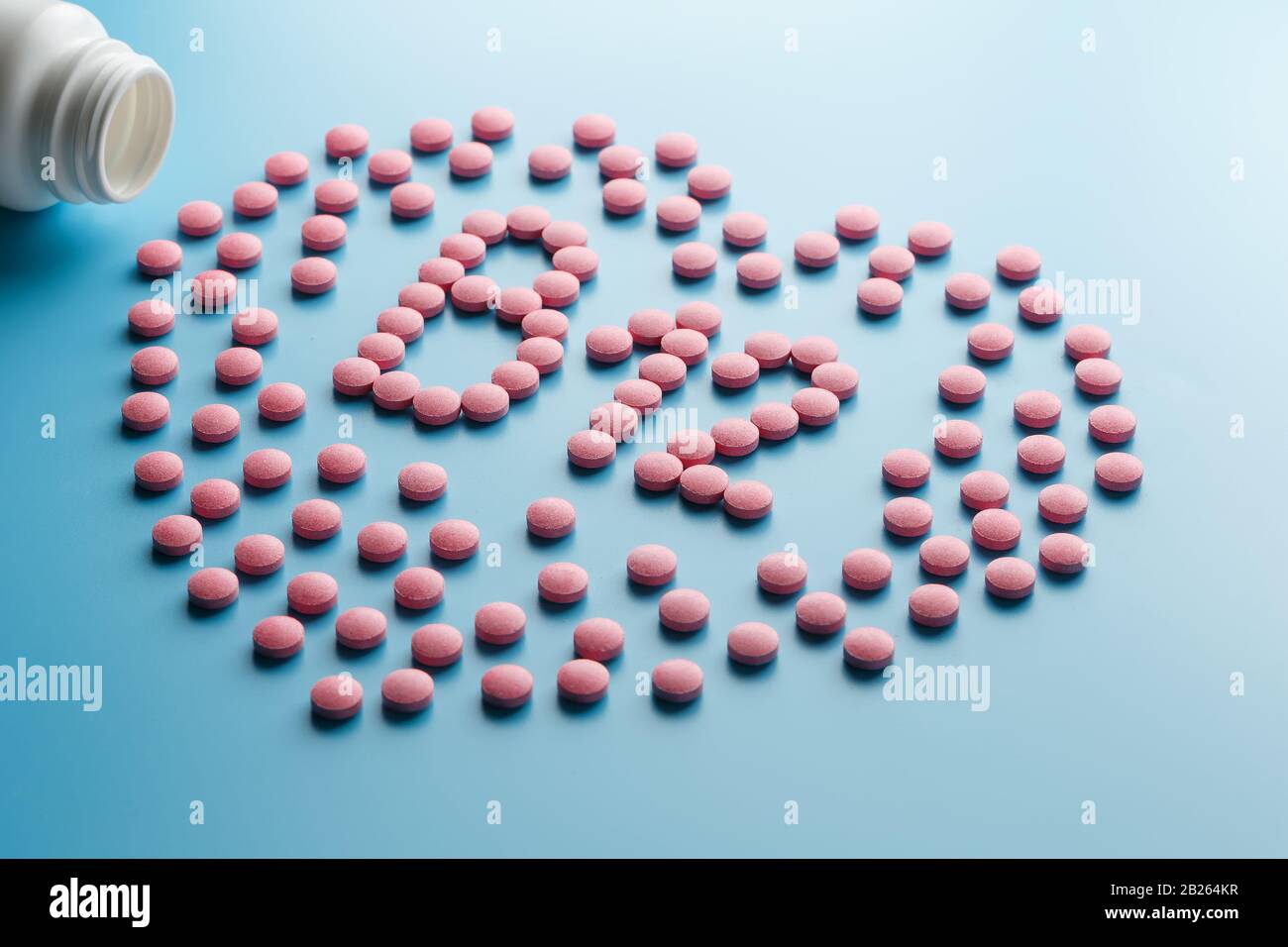 Pink tablets in the form of B12 in the heart on a blue background ...