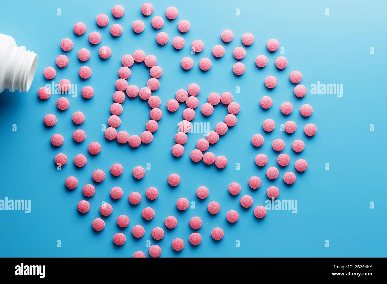 Pink tablets in the form of B12 in the heart on a blue background ...