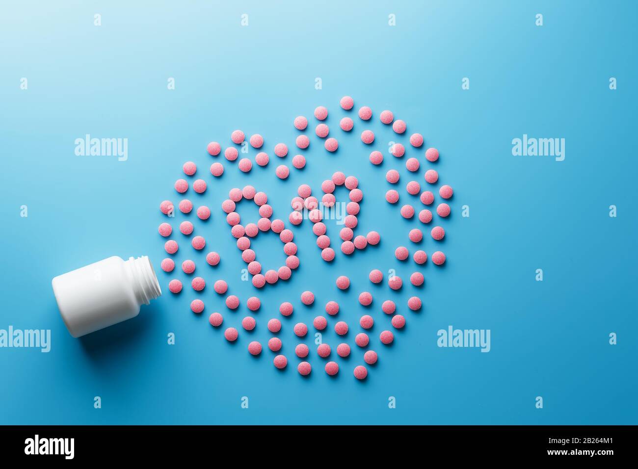 Pink tablets in the form of B12 in the heart on a blue background ...