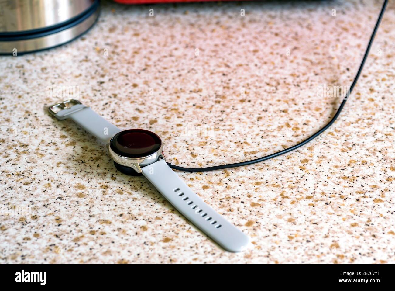 smart watch wireless charging on charging pad on kitchen worktop table ...