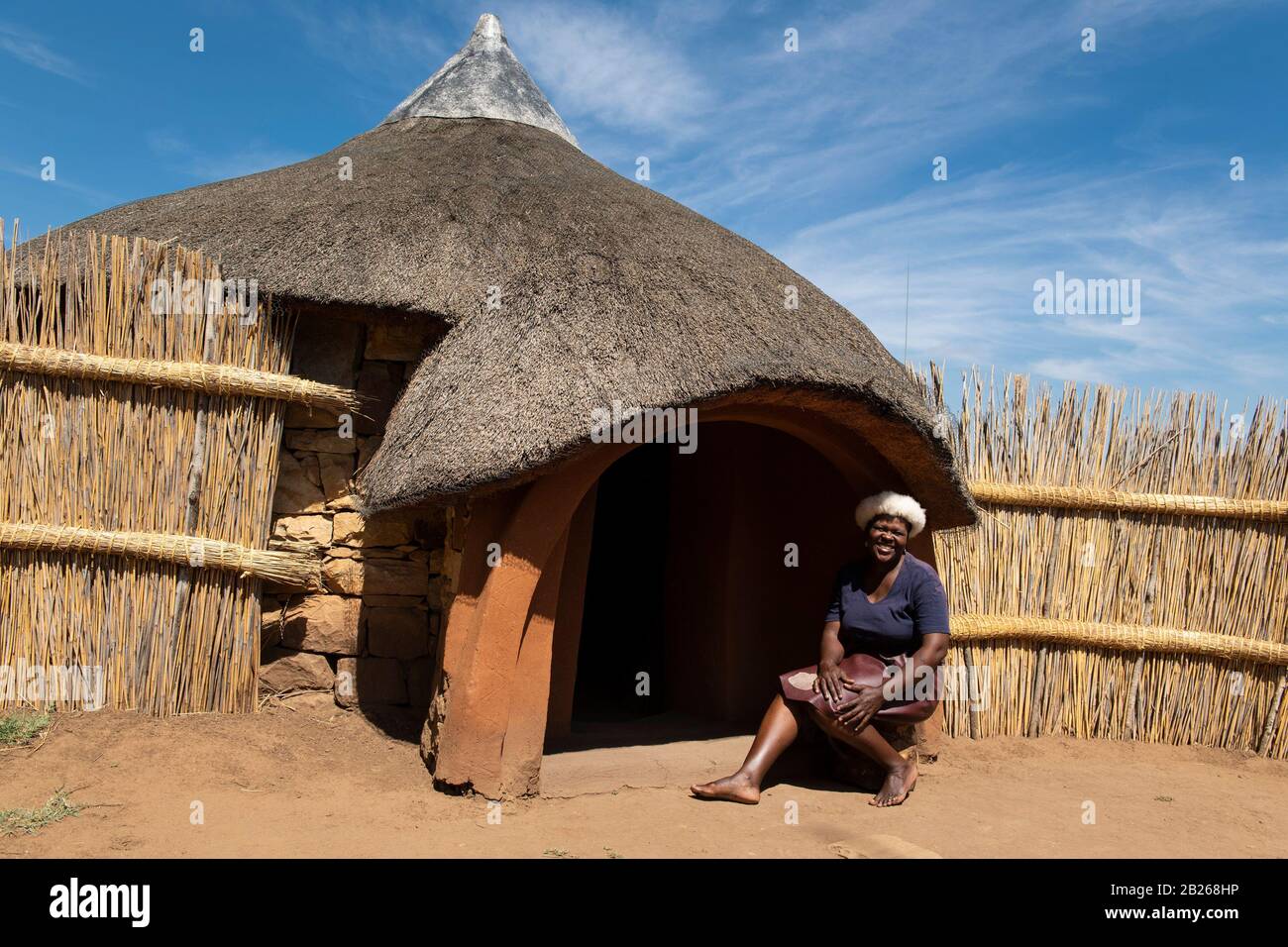 Basotho woman in front of traditional hut, Thaba Bosiu Cultural Village ...