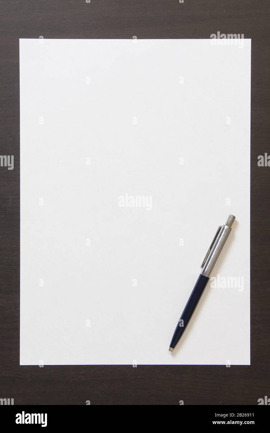 Template of white paper with pen on dark wenge color wooden background ...