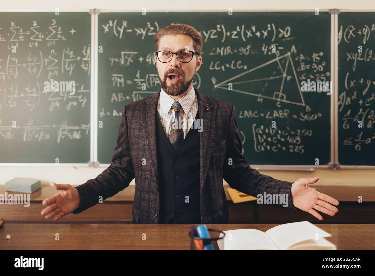 Smart bearded professor in suit and glasses explaining new material ...