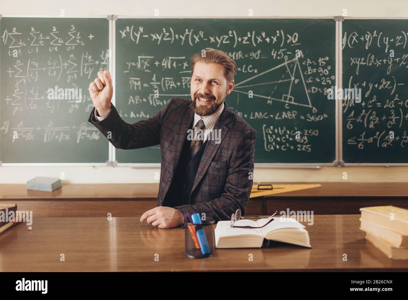 Smiling math teacher encouraging the audience making a fist upwards ...