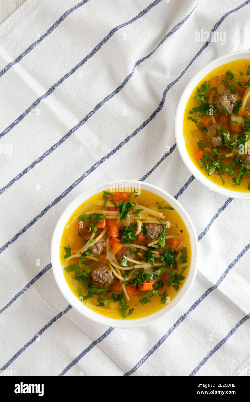 Homemade Sopa a La Minuta in white bowls on cloth, top view. Flat lay ...