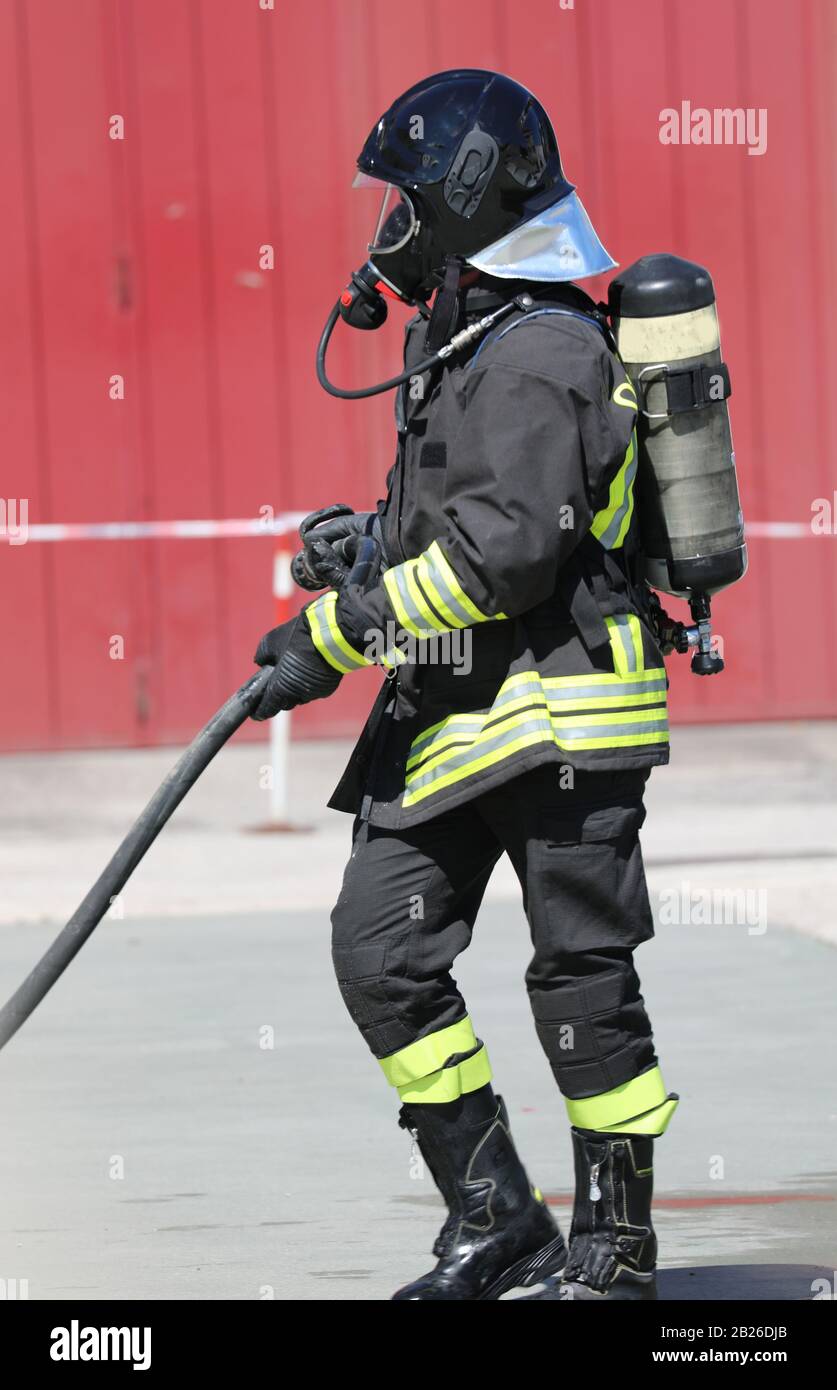 fireman with hardhat and oxygen cylinder with respirator during an ...