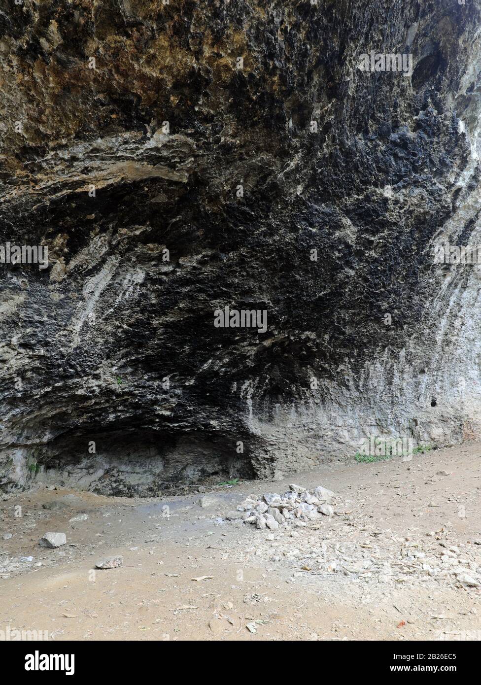 large cave in the rock used by primitive men as a shelter in ...