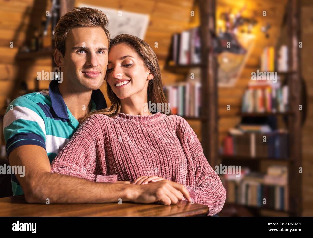 Young and beautiful happy family together in modern wooden house ...