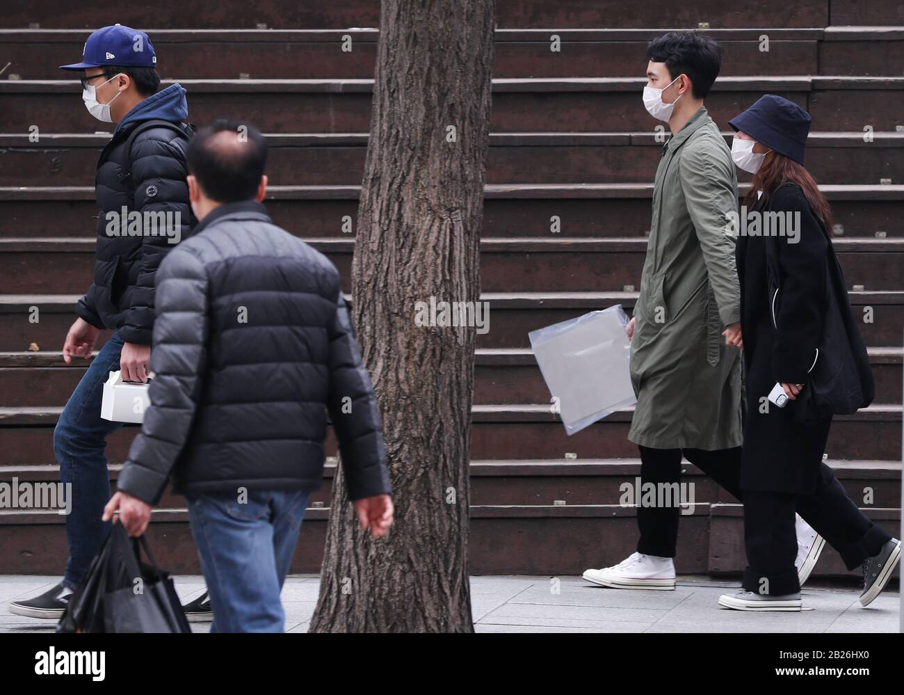 Seoul, South Korea. 1st Mar, 2020. People wearing face masks walk along ...
