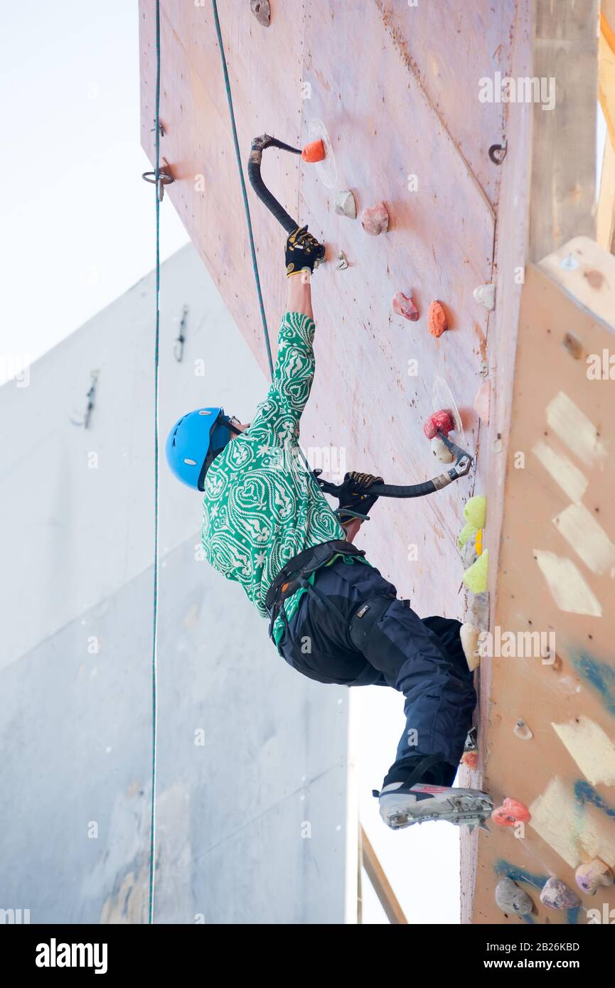 Man climbs upward on ice climbing competition Stock Photo - Alamy